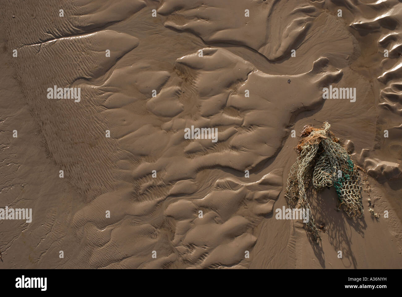 Sand Patterns and a discarded fishing net Stock Photo - Alamy
