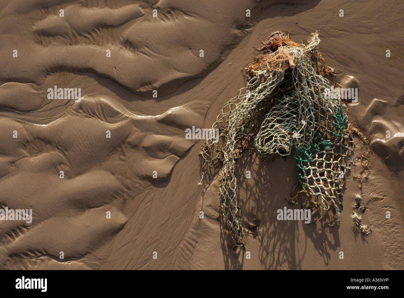 Sand Patterns and a discarded fishing net Stock Photo - Alamy