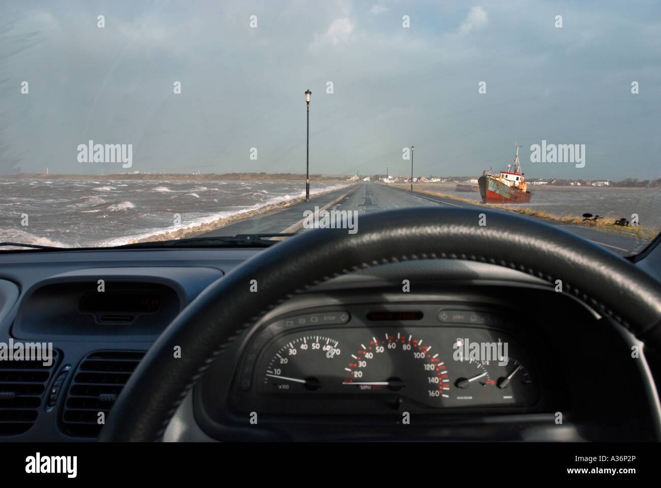 Stormy Day A wind swept road viewed from inside a car showing the view ...