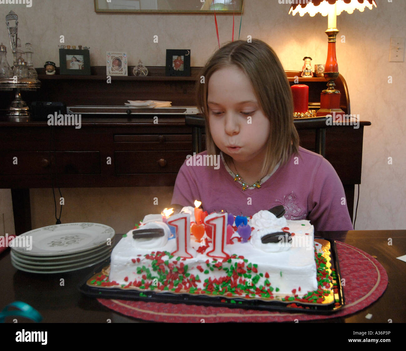 A child blows out the candles on a birthday cake Stock Photo - Alamy