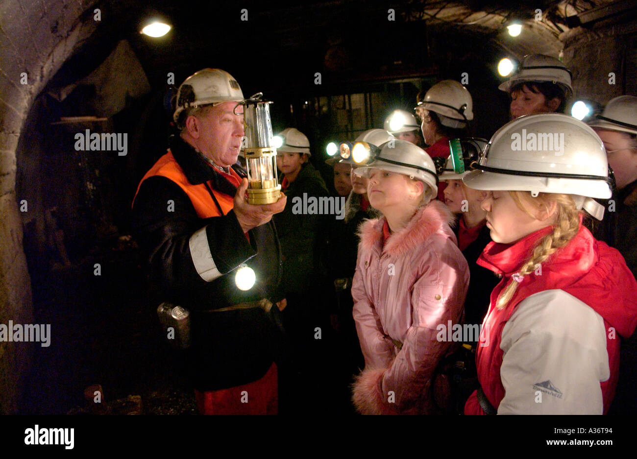 Guide a former miner giving school pupils an underground tour at Big ...
