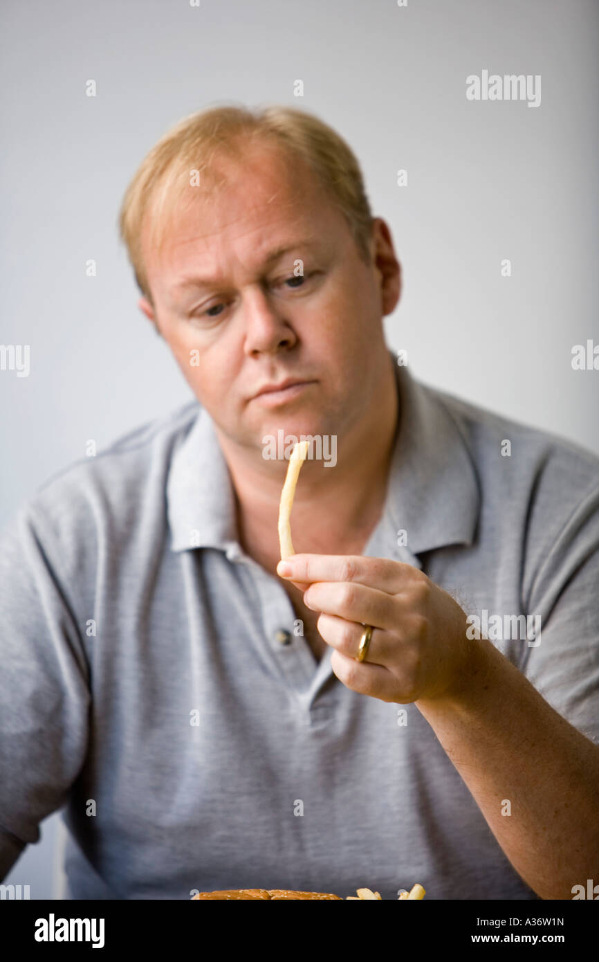 A man contemplates a single chip or French fry Stock Photo - Alamy