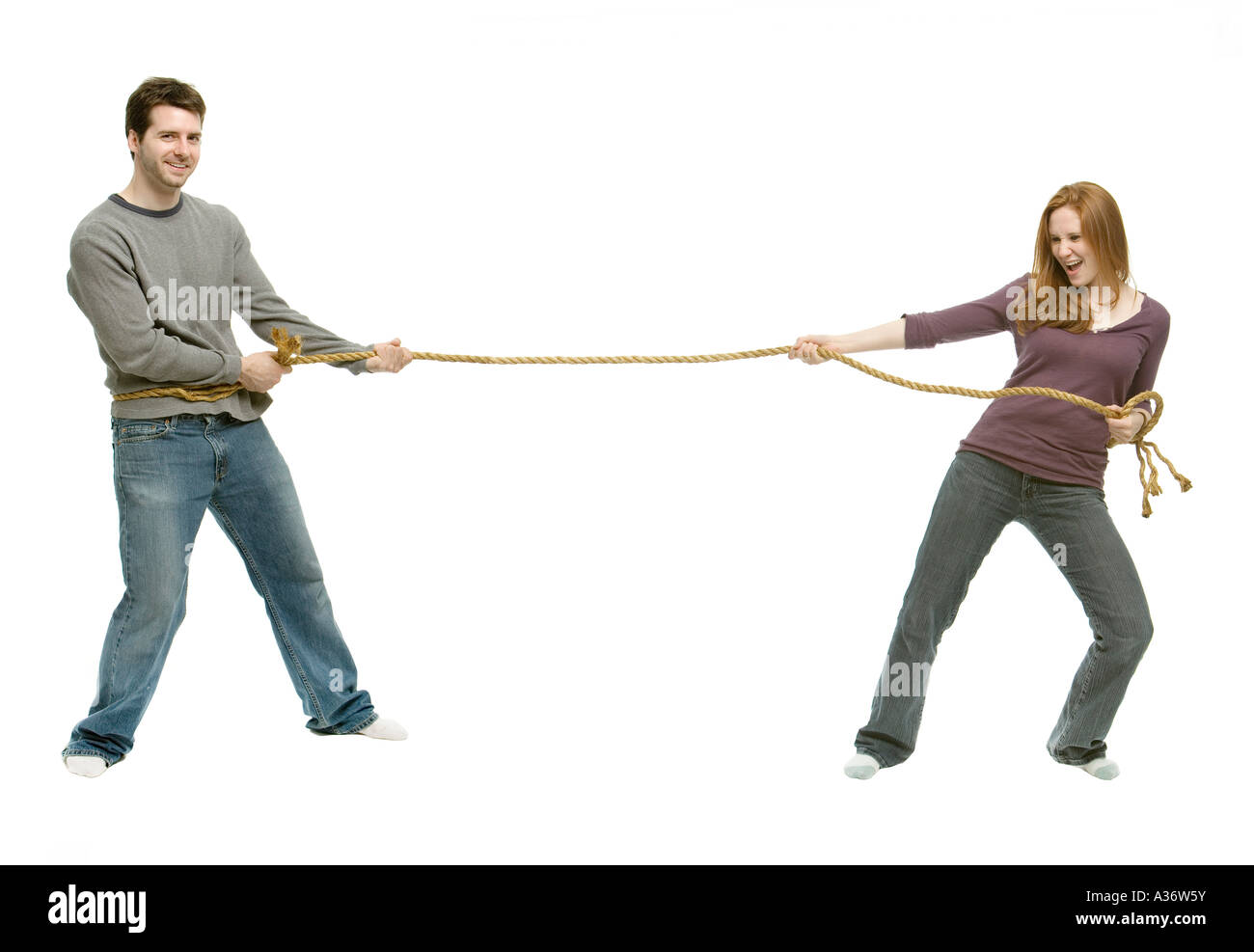 young couple in a tug of war with a rope on a white background Stock ...