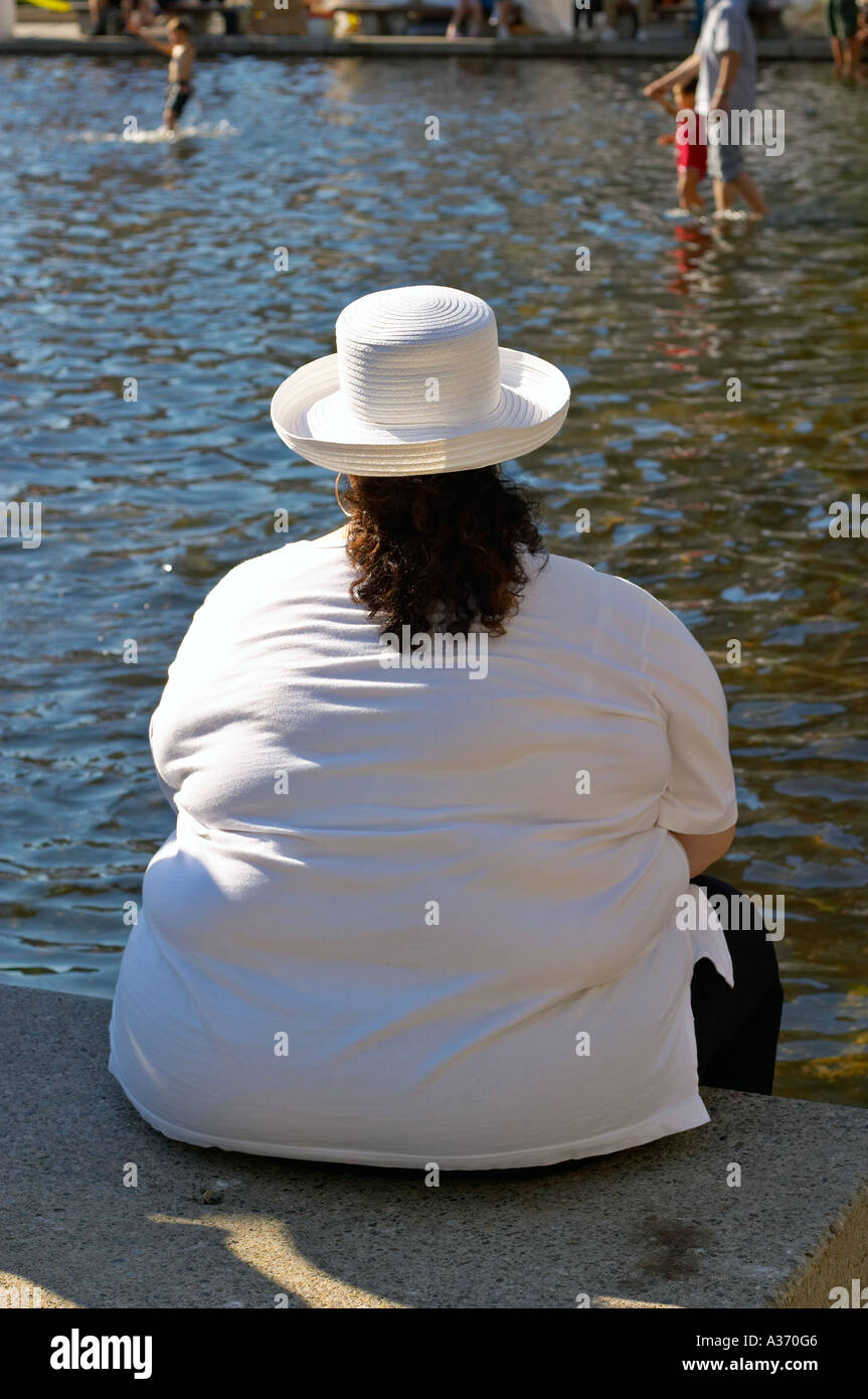Anonymous overweight woman sitting on a step near water Stock Photo - Alamy