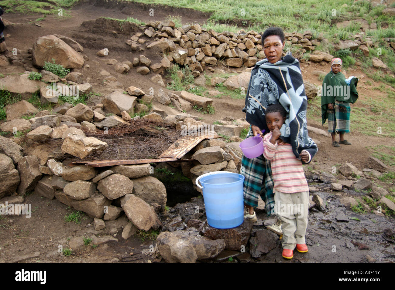 A Basotho woman and her child at a water hole in the village of ...
