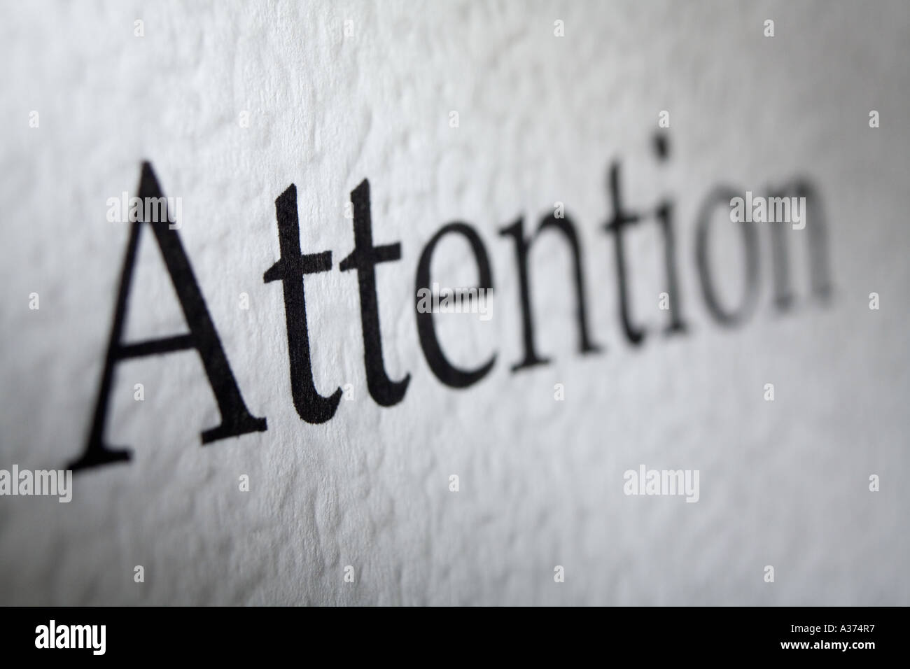 the word attention printed on to texture paper Stock Photo - Alamy