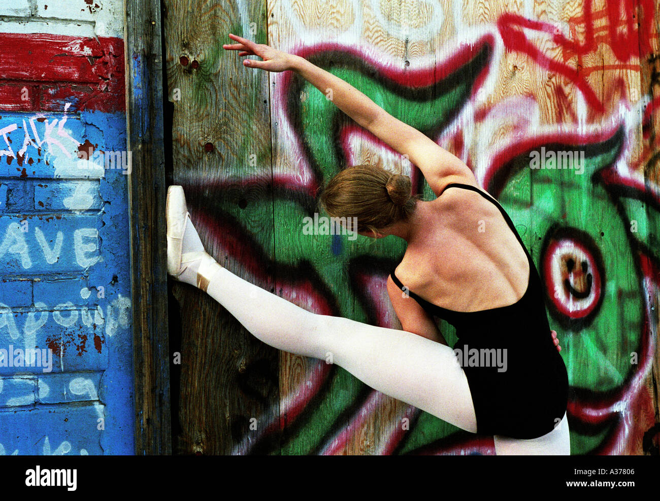 ballet dancer with leg up and arm extended over head in a stretching ...