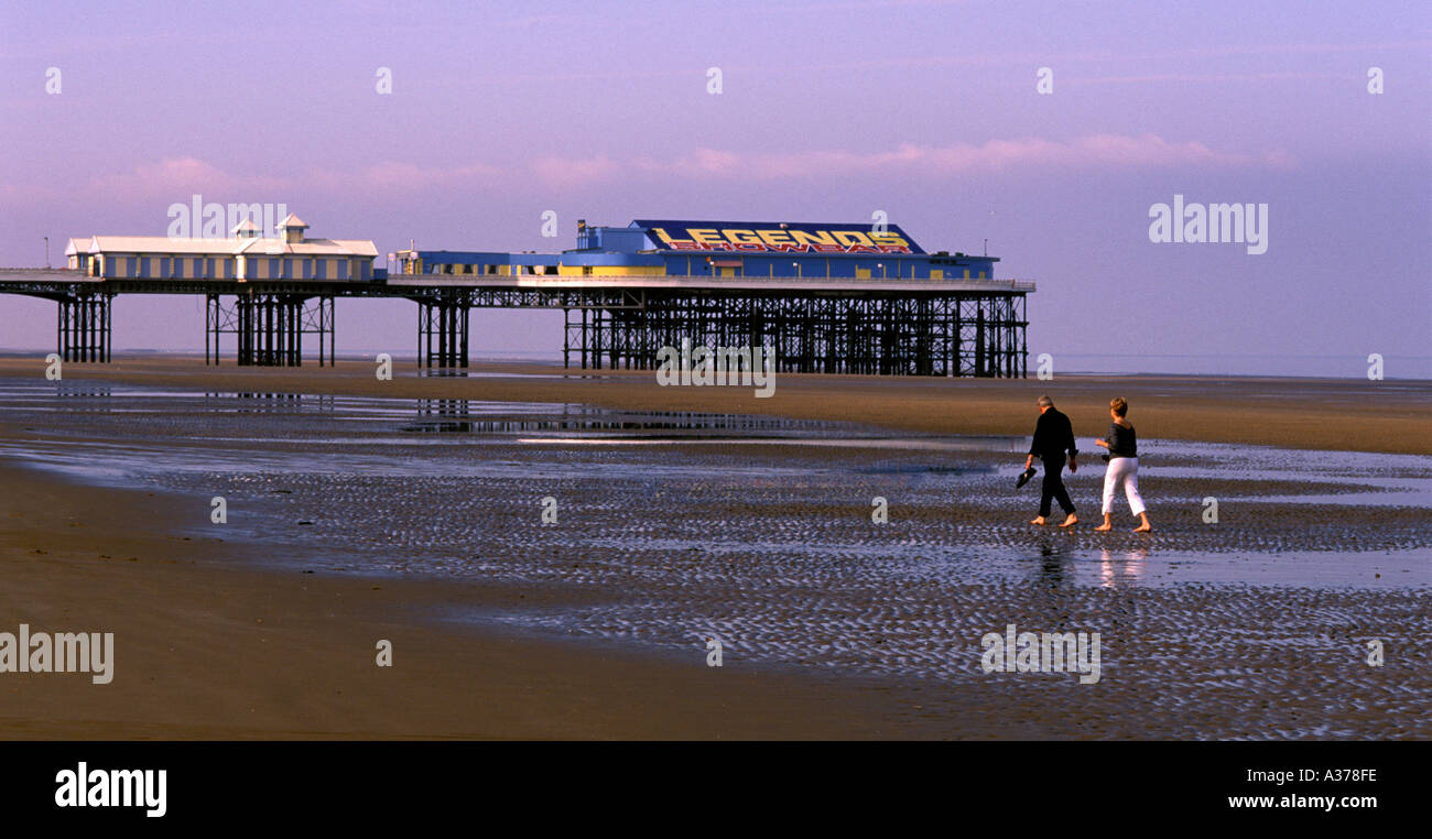 A couple walking on the Blackpool beach early in the morning England ...