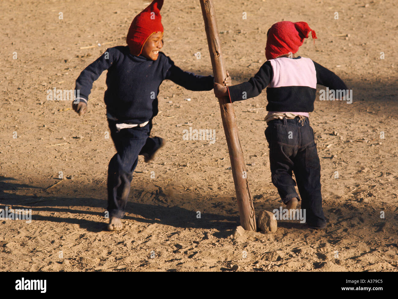 Aymara Indian children playing running around a pole Suriqui Island ...