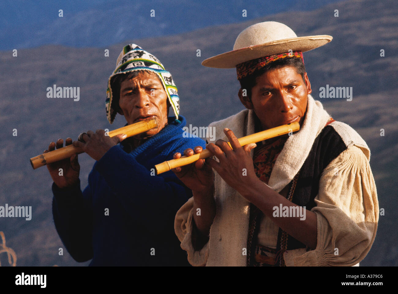 Men of Quechua ethnic group playing flute at a traditional village ...
