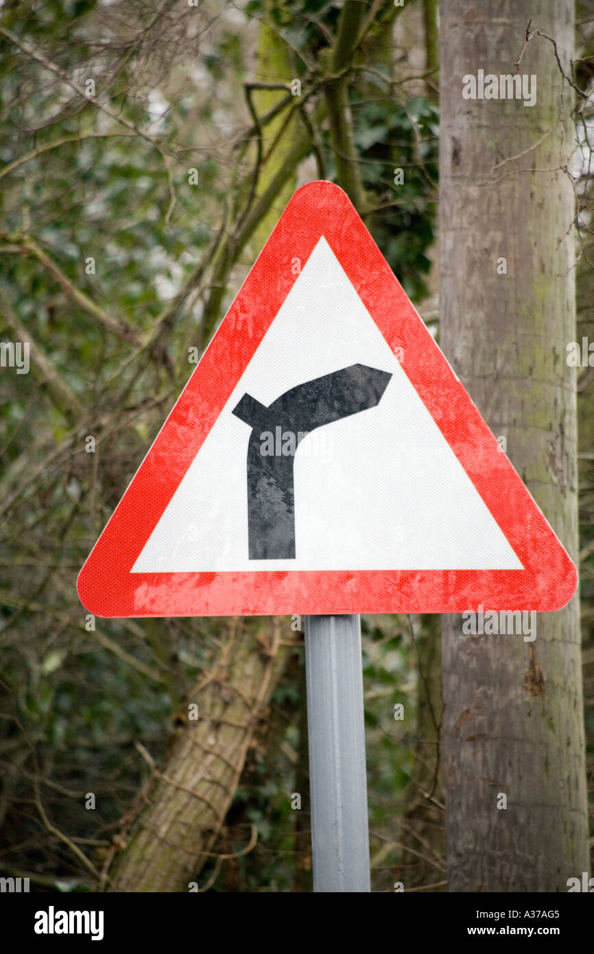 traingle warning road sign off a right hand bend ahead trees in the ...