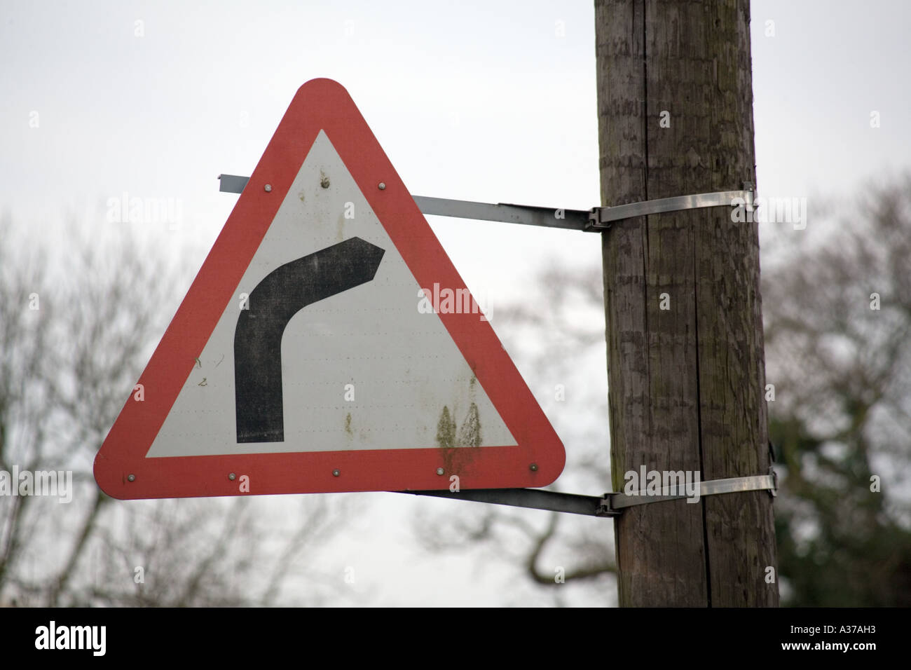 traingle warning road sign off a right hand bend ahead sky in the back ...