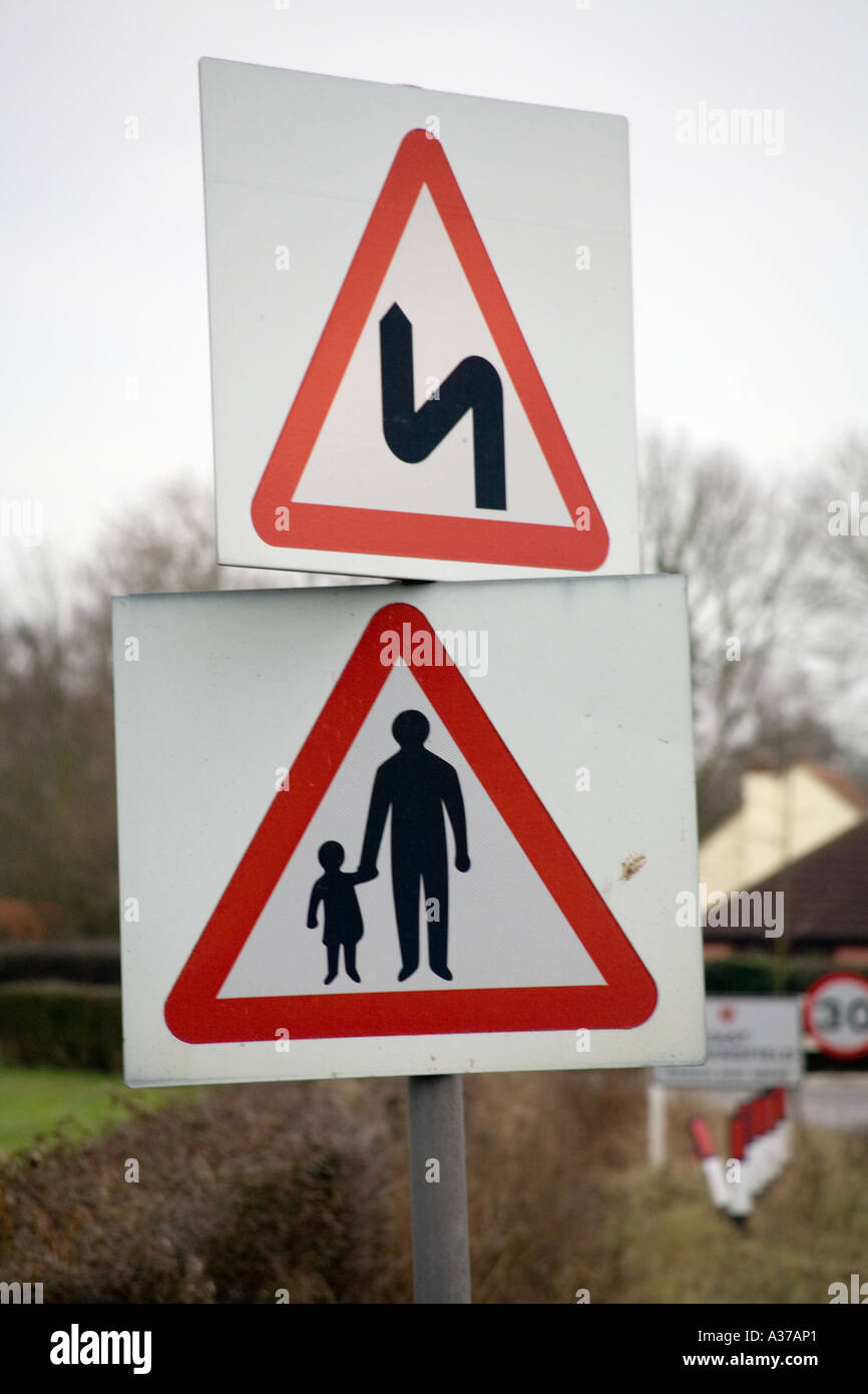 two tranigle warning road signs top one is watch out for bendy roads ...