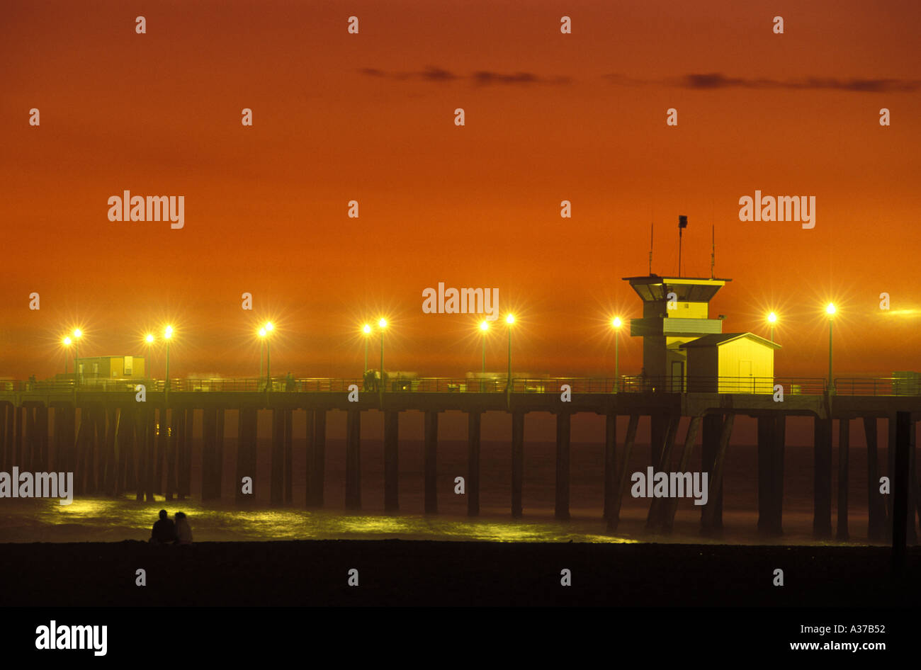 Huntington Beach pier at night with couple on beach California Stock ...