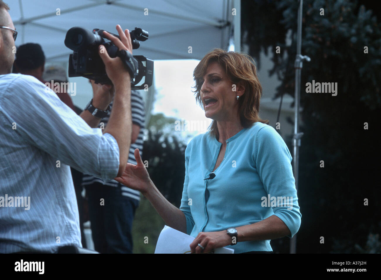 Television news reporter an dcrew filing story in the rain Stock Photo ...