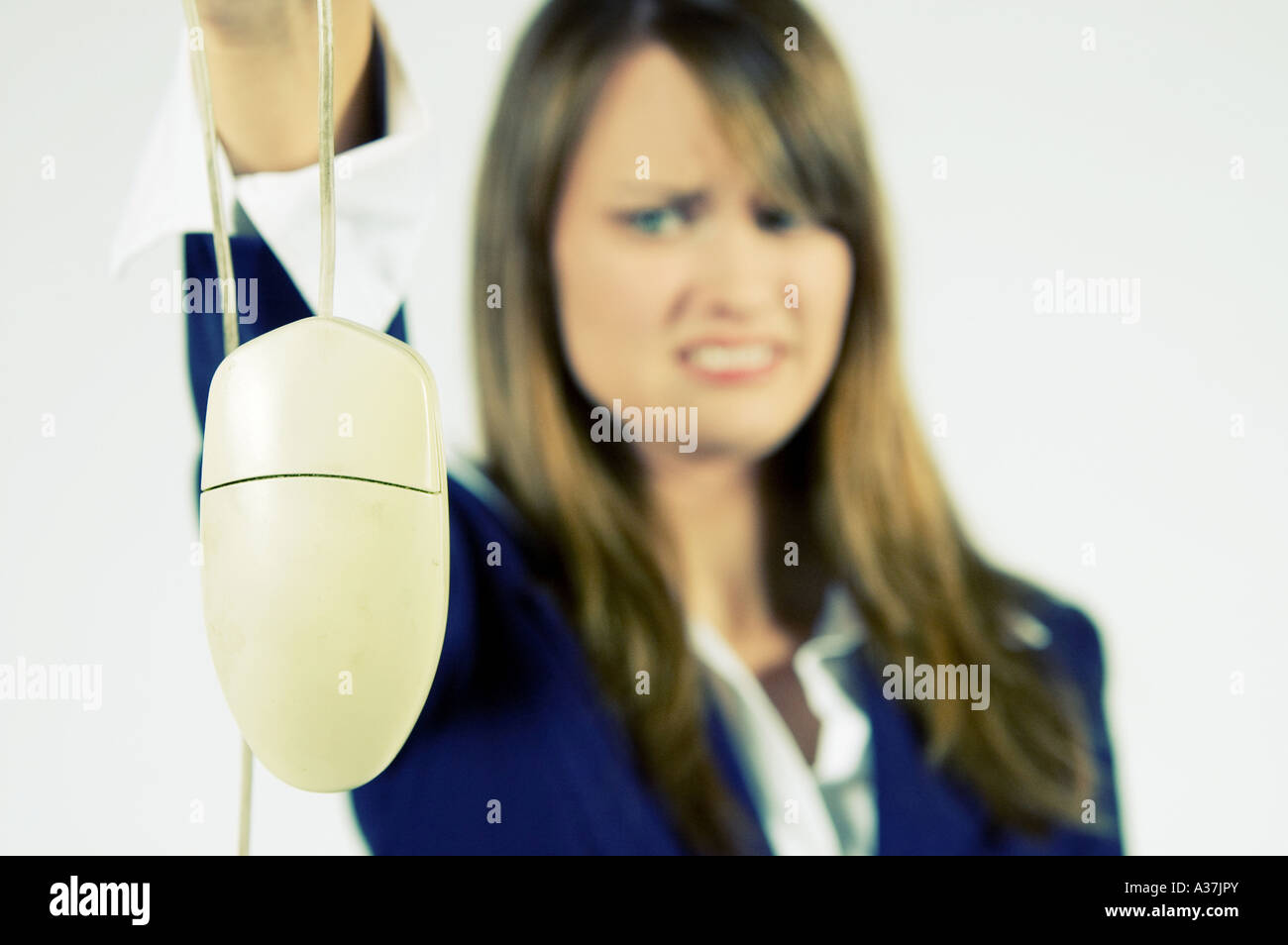 Beautiful woman in a blue business suit holds a mouse away from her in ...