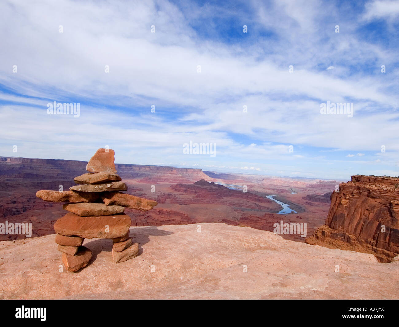 Stone man built right on the edge of a huge cliff overlooking red rock ...