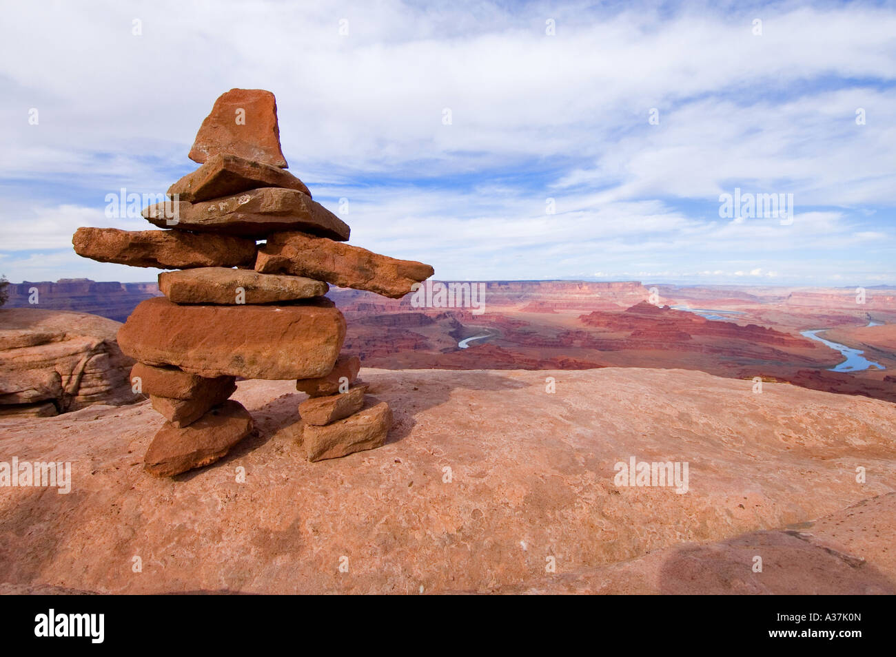 Stone man built right on the edge of a huge cliff overlooking red rock ...