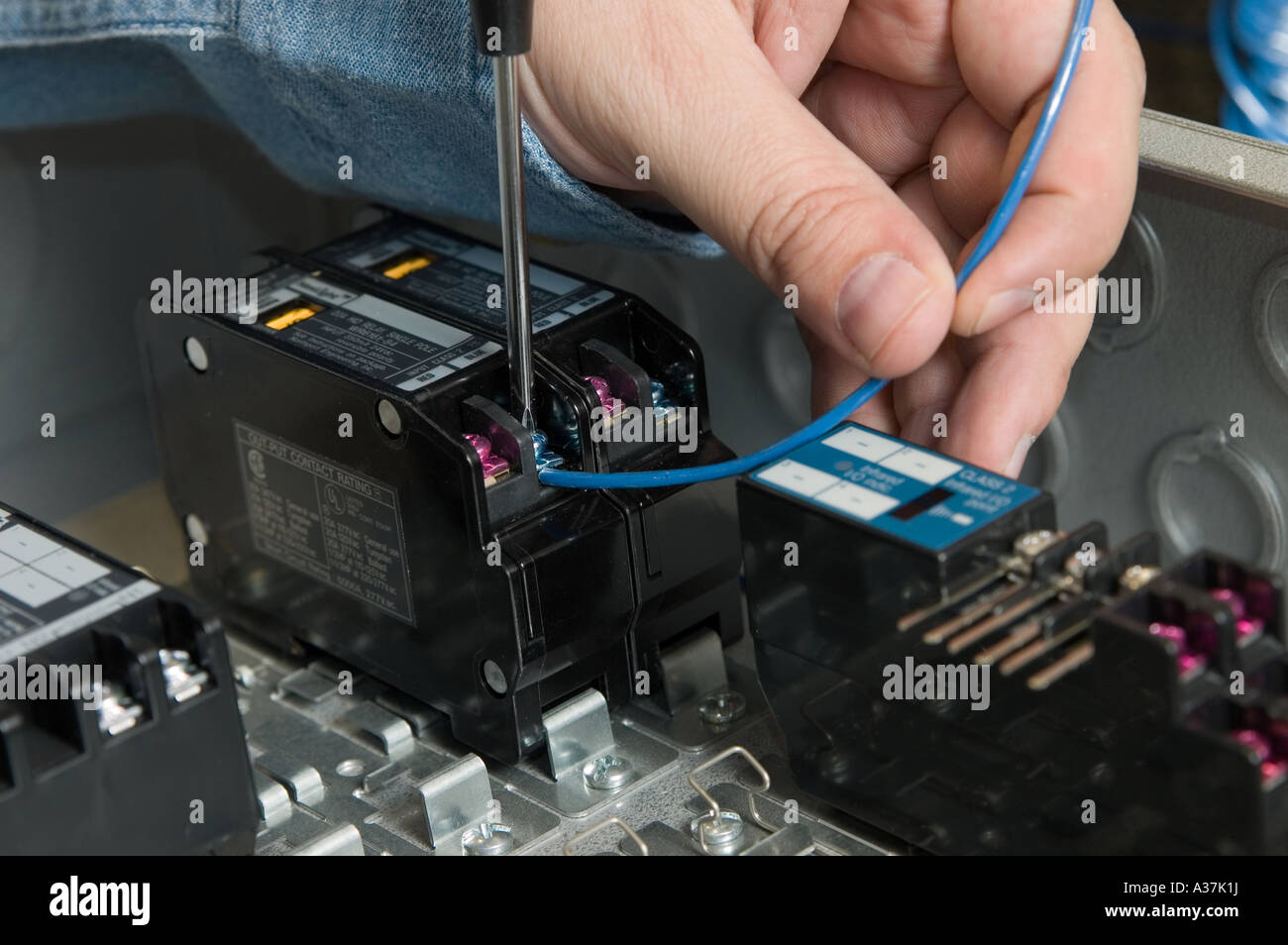 Male technician wiring electronics and wire into a control panel ...