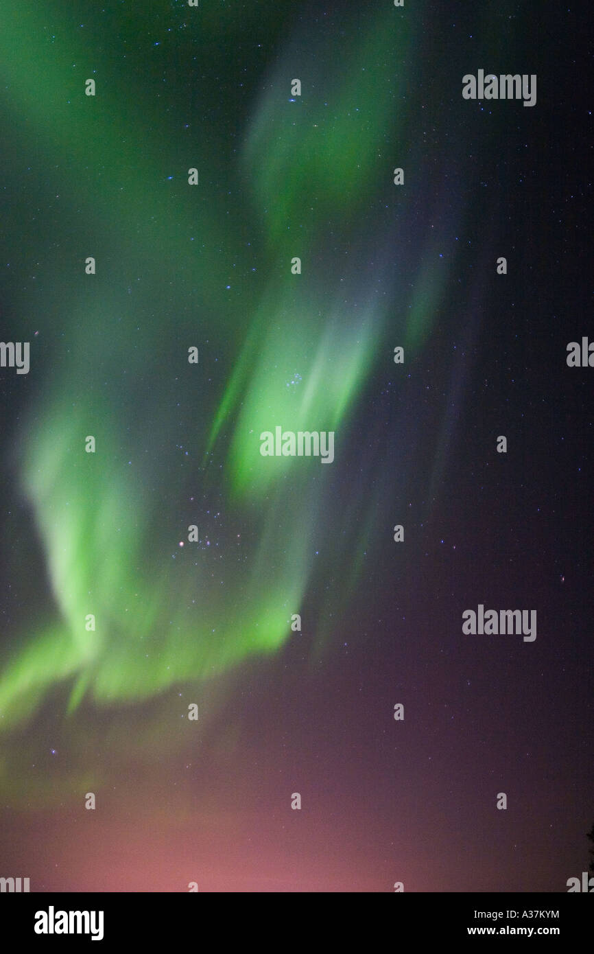 Northern lights over town lights glow Stock Photo - Alamy