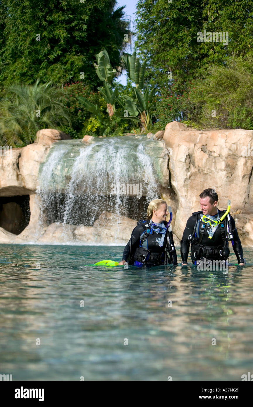 Scuba diver couple walk out of waterfall pool Discovery Cove Orlando FL ...