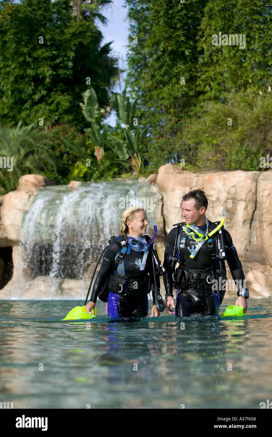 Scuba diver couple walk out of waterfall pool Discovery Cove Orlando FL ...