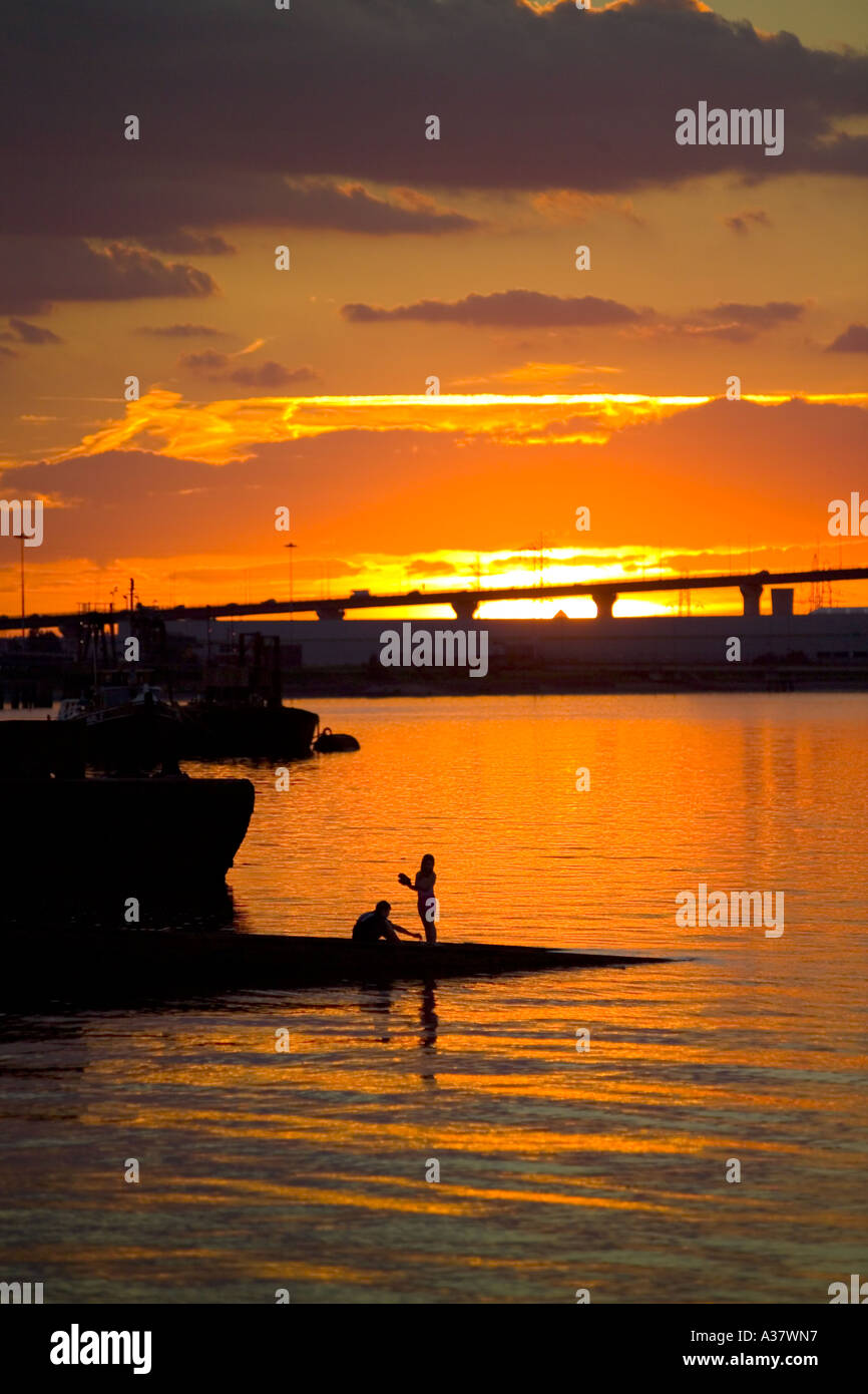 Children playing on a slipway on the banks of the Thames in Greenhithe ...