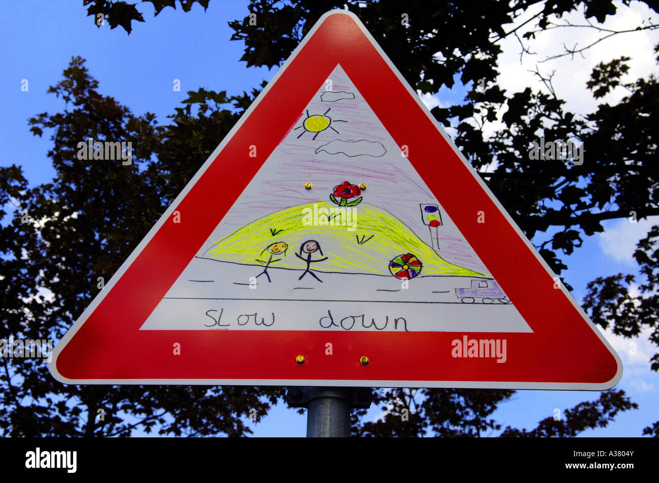 slow down red triangle road sign traffic calming measures blue sky ...