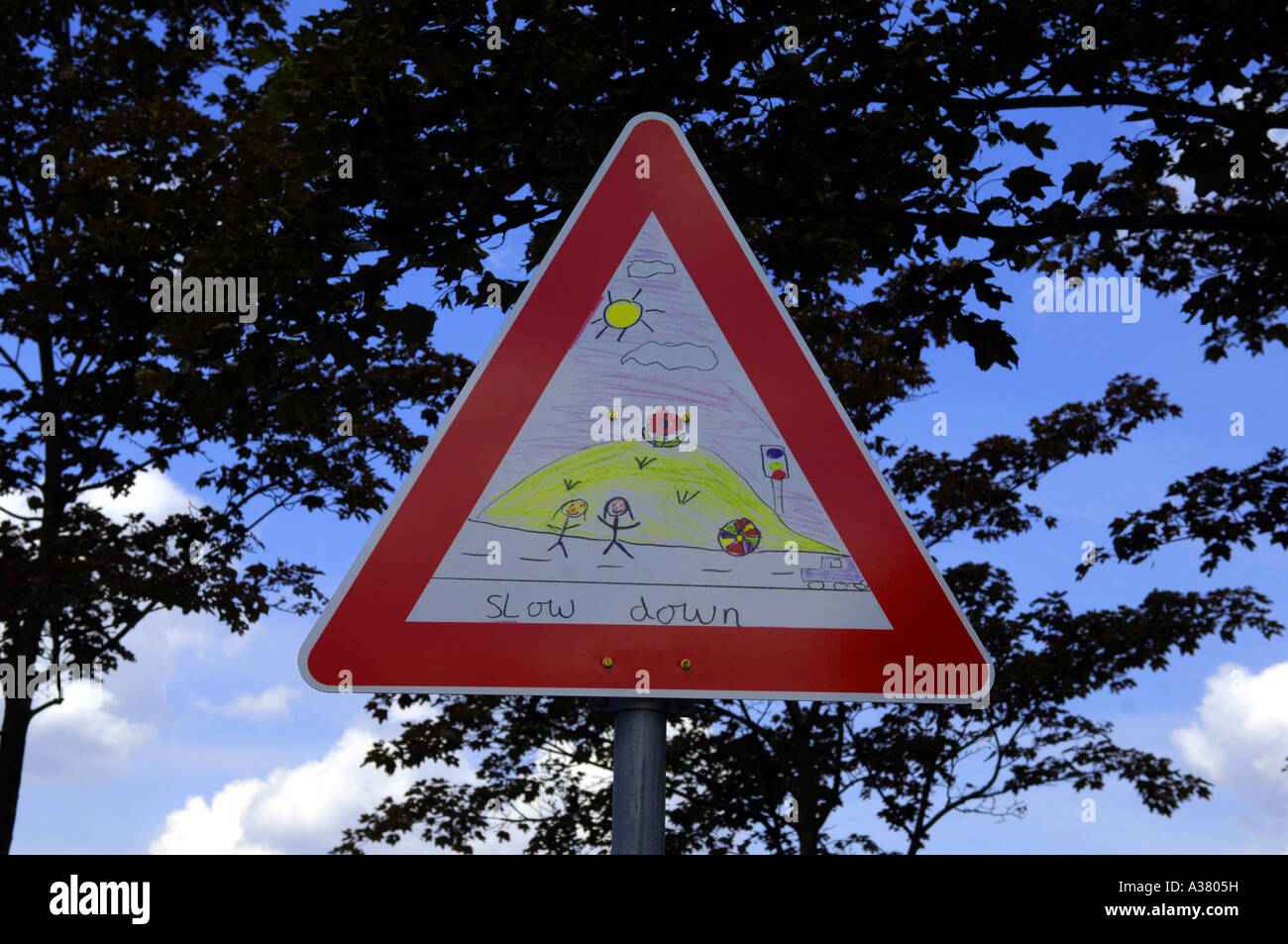 slow down red triangle road sign traffic calming measures blue sky ...