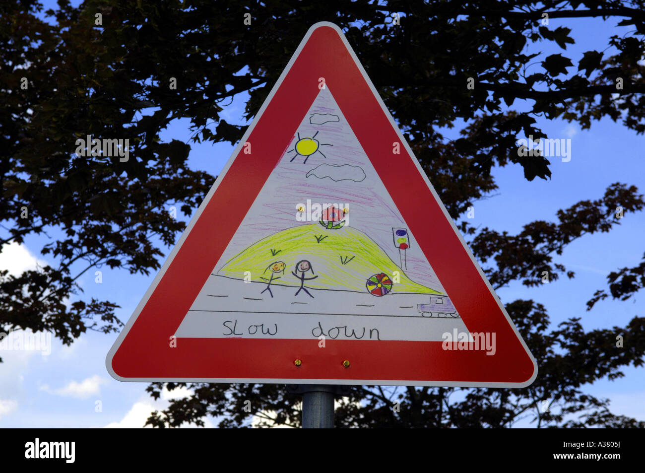 slow down red triangle road sign traffic calming measures blue sky ...