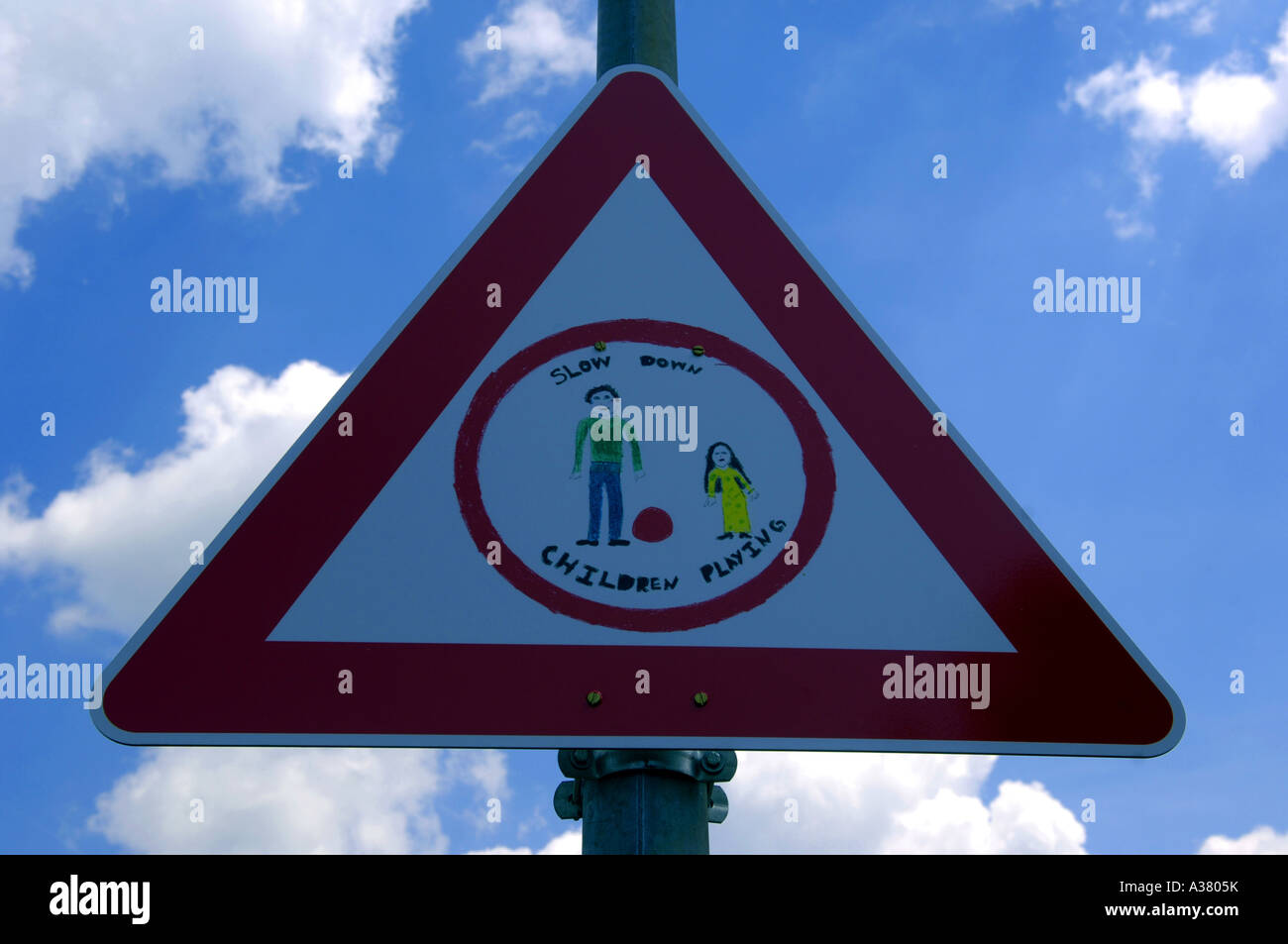 slow down red triangle road sign traffic calming measures blue sky ...