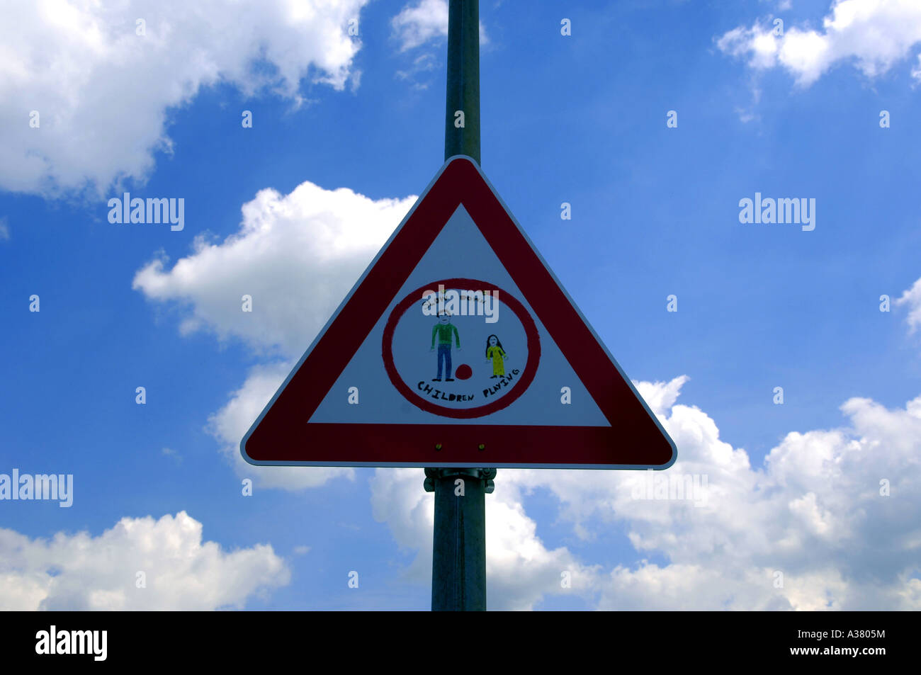 slow down red triangle road sign traffic calming measures blue sky ...