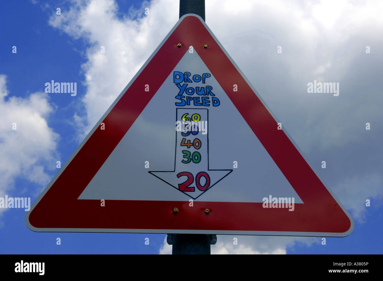 slow down red triangle road sign traffic calming measures blue sky ...