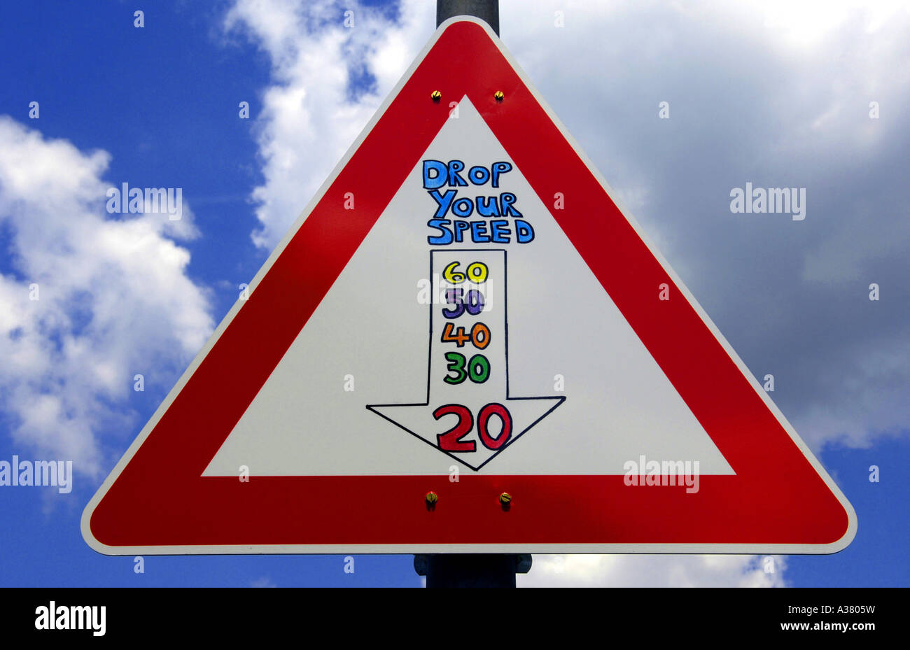 slow down red triangle road sign traffic calming measures blue sky ...