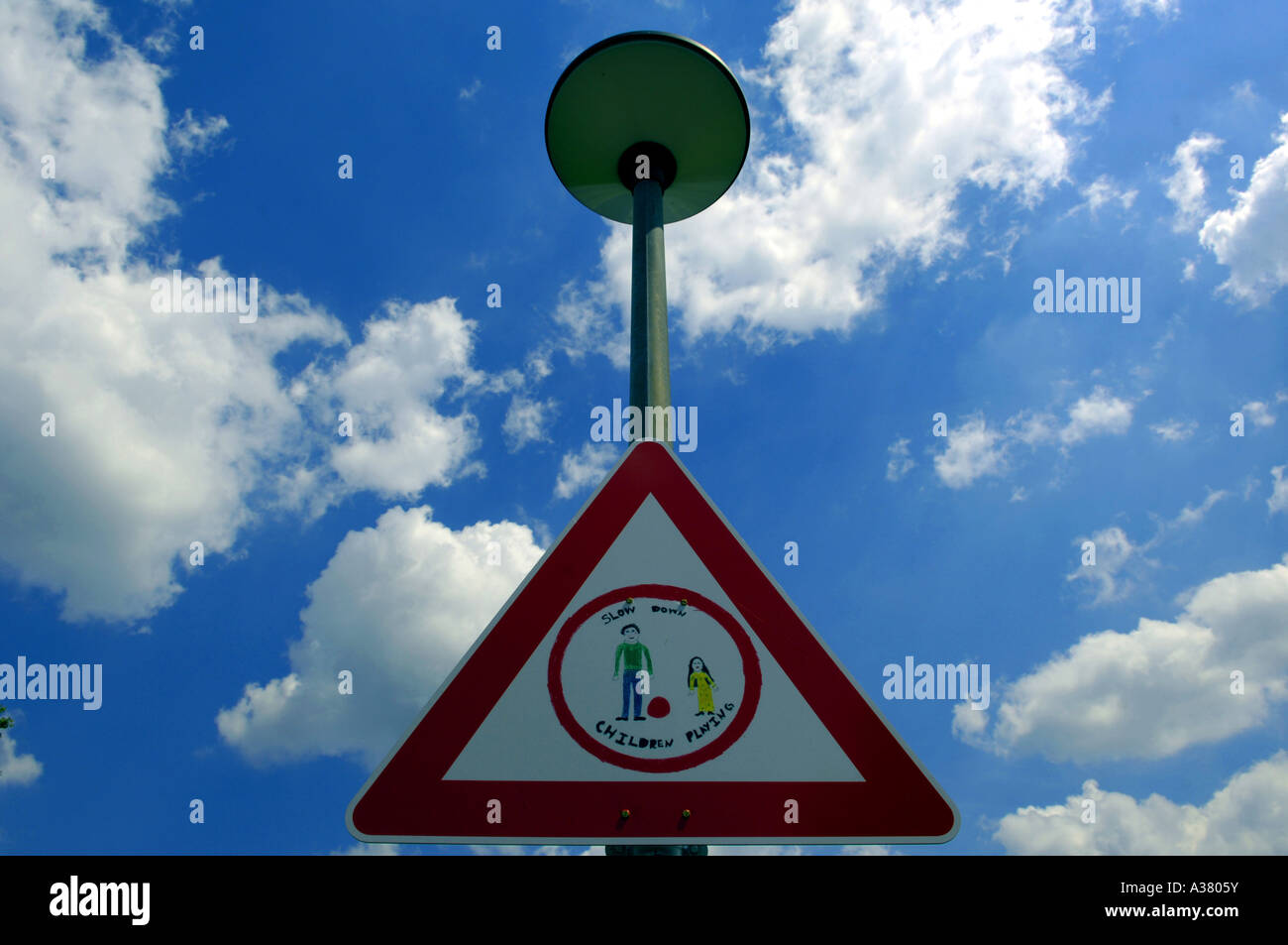 slow down red triangle road sign traffic calming measures blue sky ...
