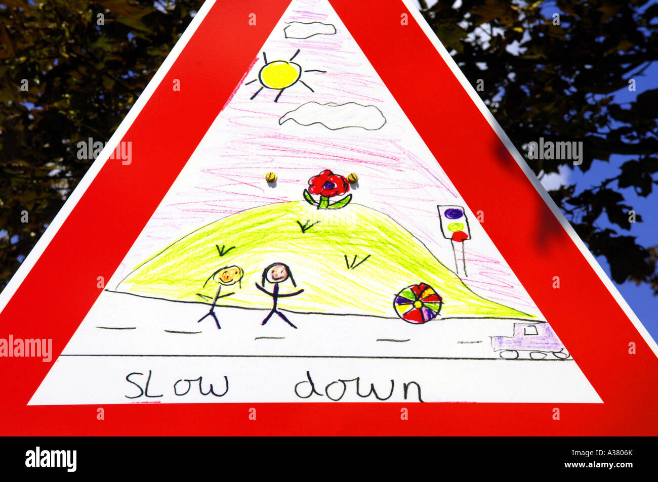 slow down red triangle road sign traffic calming measures blue sky ...