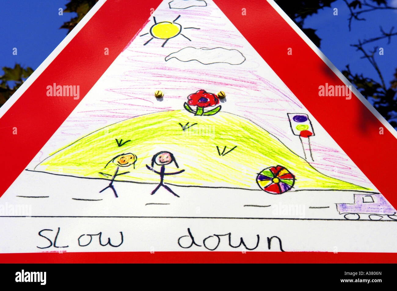 slow down red triangle road sign traffic calming measures blue sky ...