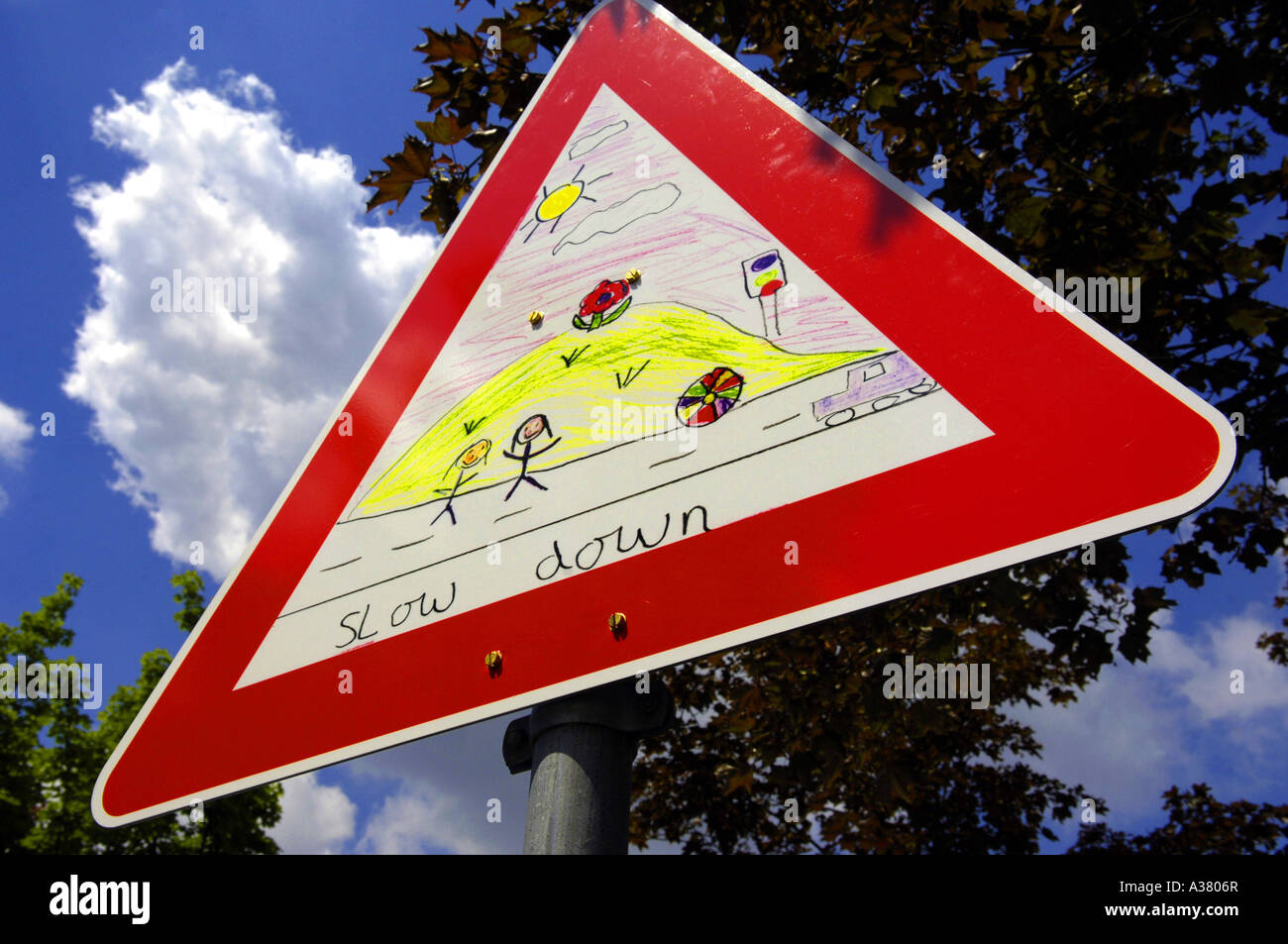 slow down red triangle road sign traffic calming measures blue sky ...