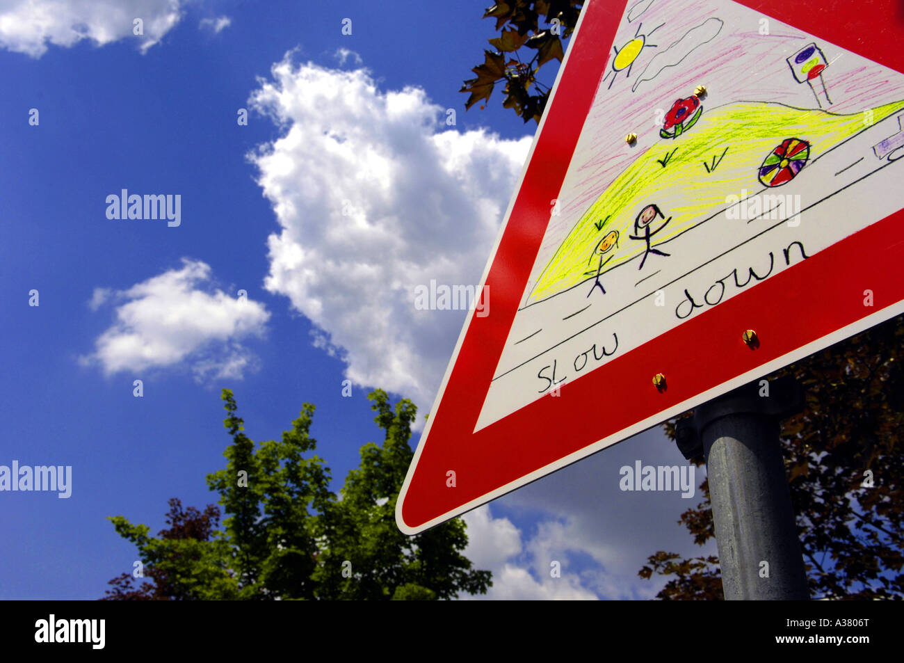 slow down red triangle road sign traffic calming measures blue sky ...