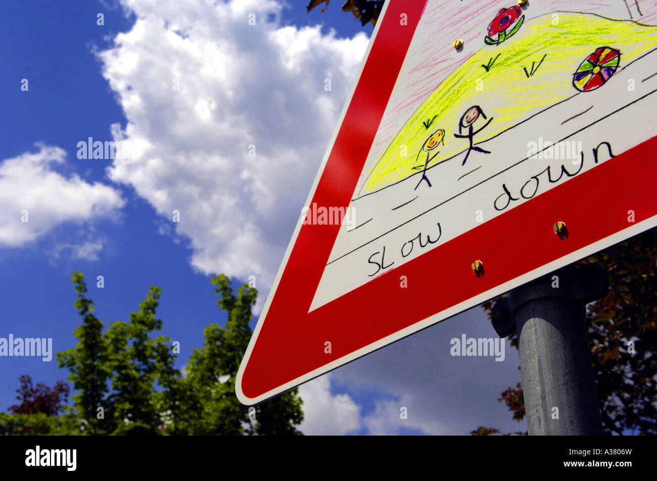 slow down red triangle road sign traffic calming measures blue sky ...