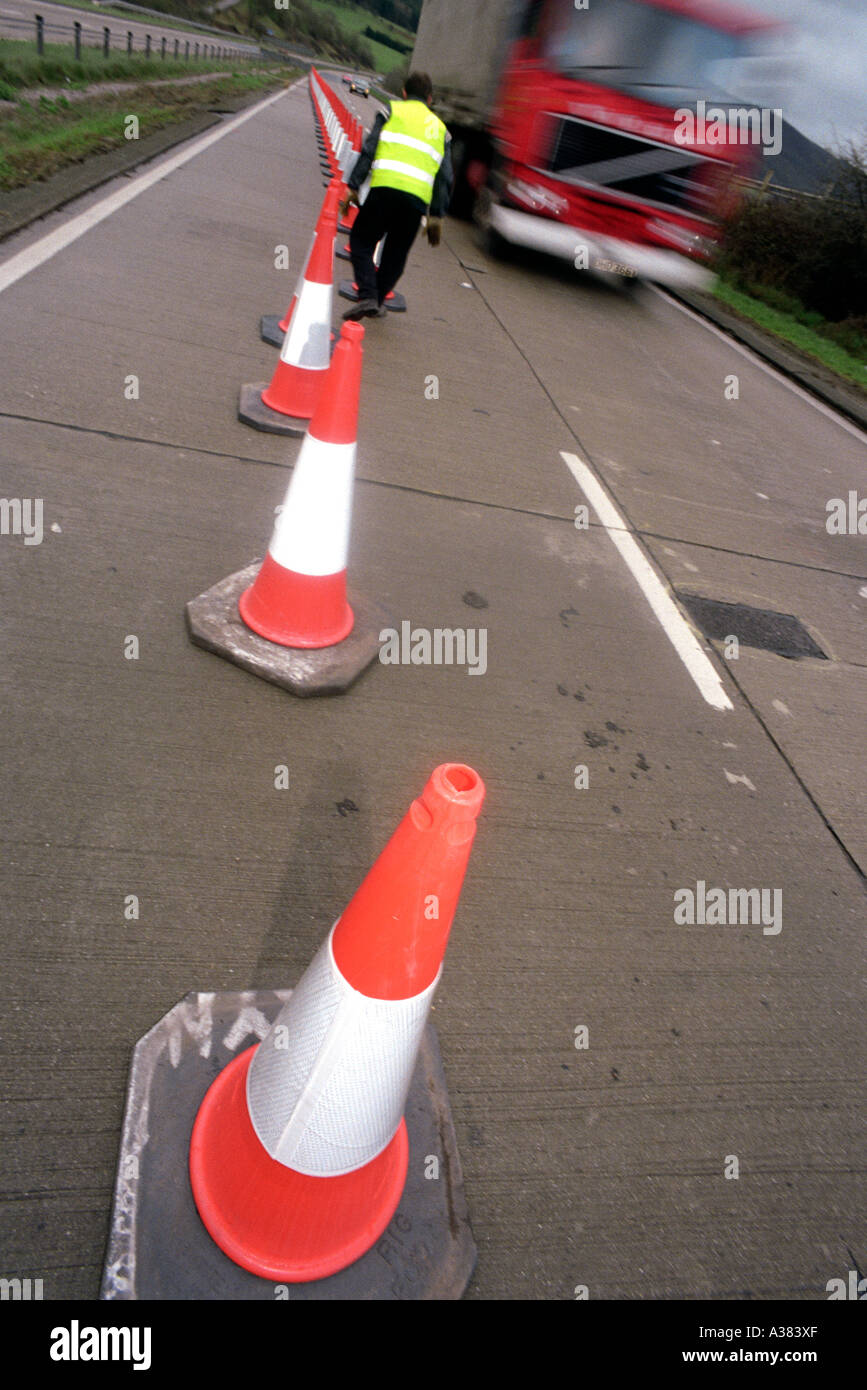 worker laying out traffic cones on the road Stock Photo - Alamy