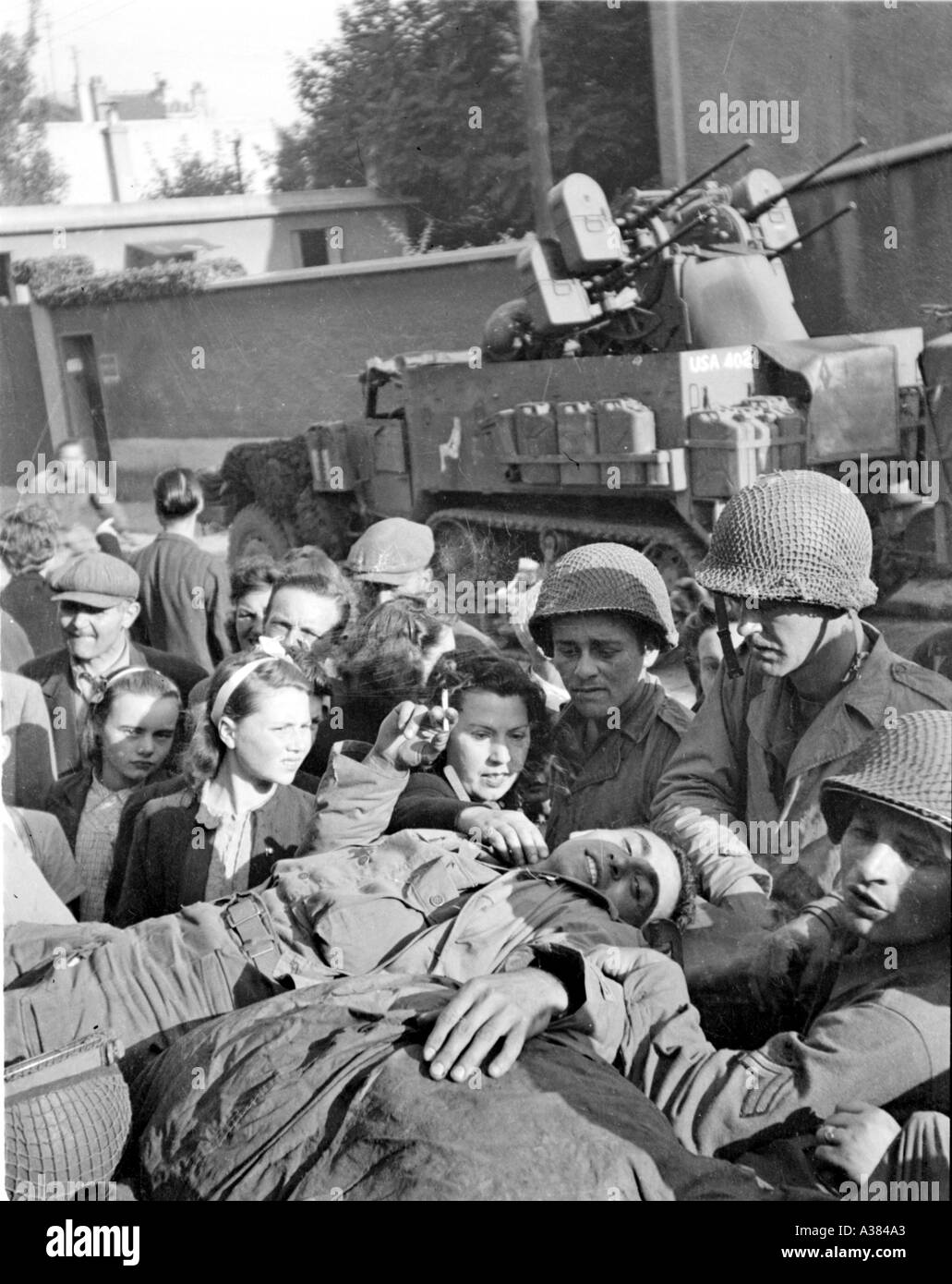 WW II Normandy wounded GI curious civilians Stock Photo - Alamy
