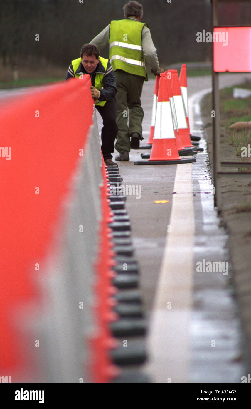 worker laying out traffic cones on the road Stock Photo - Alamy