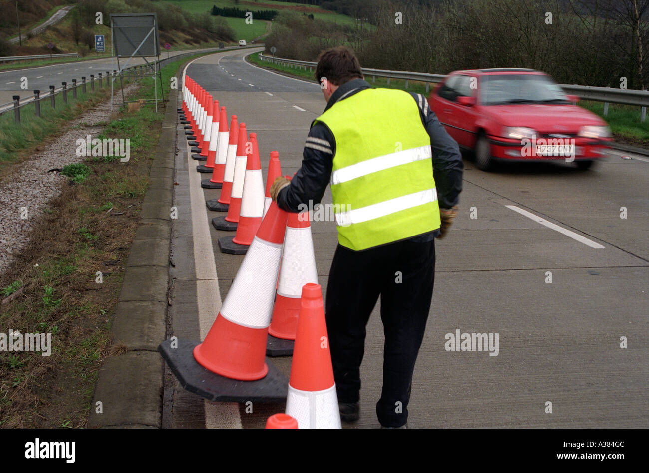 worker laying out traffic cones on the road Stock Photo - Alamy