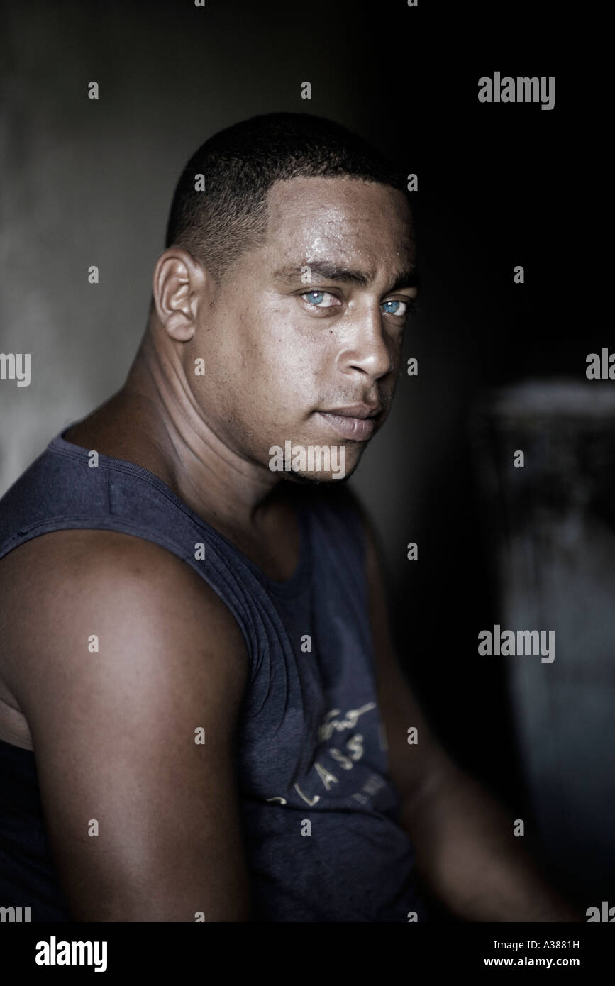 A Cuban man of African descent with light blue eyes works a pizza stand ...