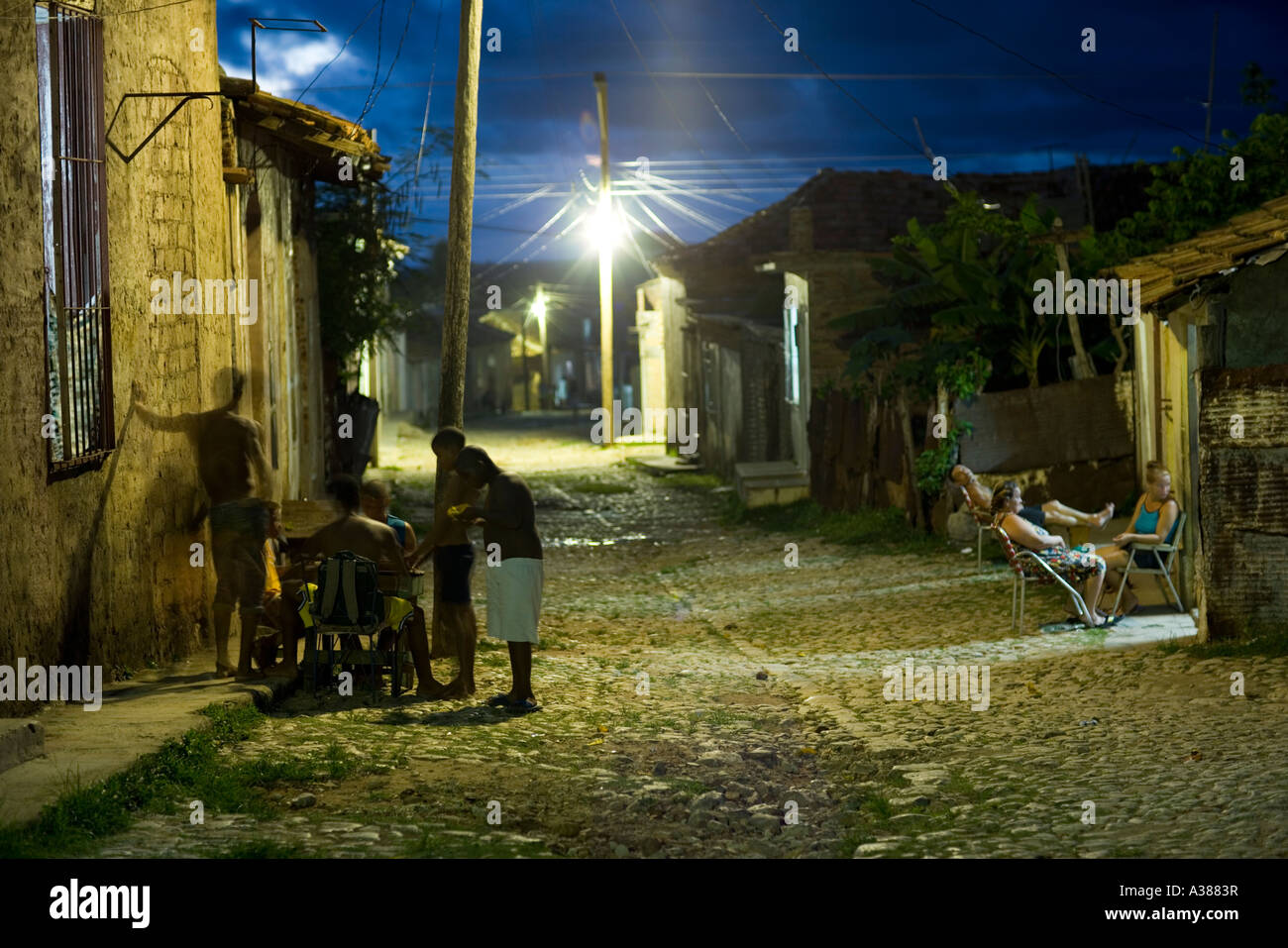Cubans hanging out in the streets of Trinidad at dusk Stock Photo - Alamy