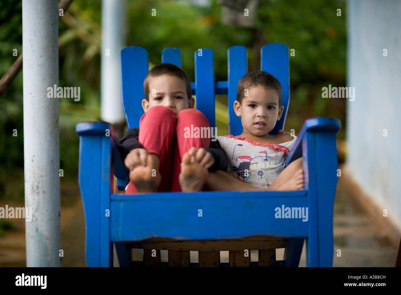Two brothers sit on a rocking chair in Vinales Stock Photo - Alamy