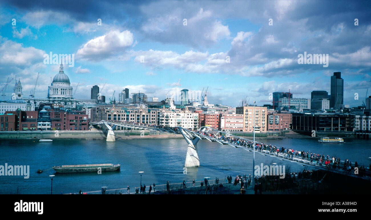Panorama of Millenium Bridge London with crowd crossing River Thames ...