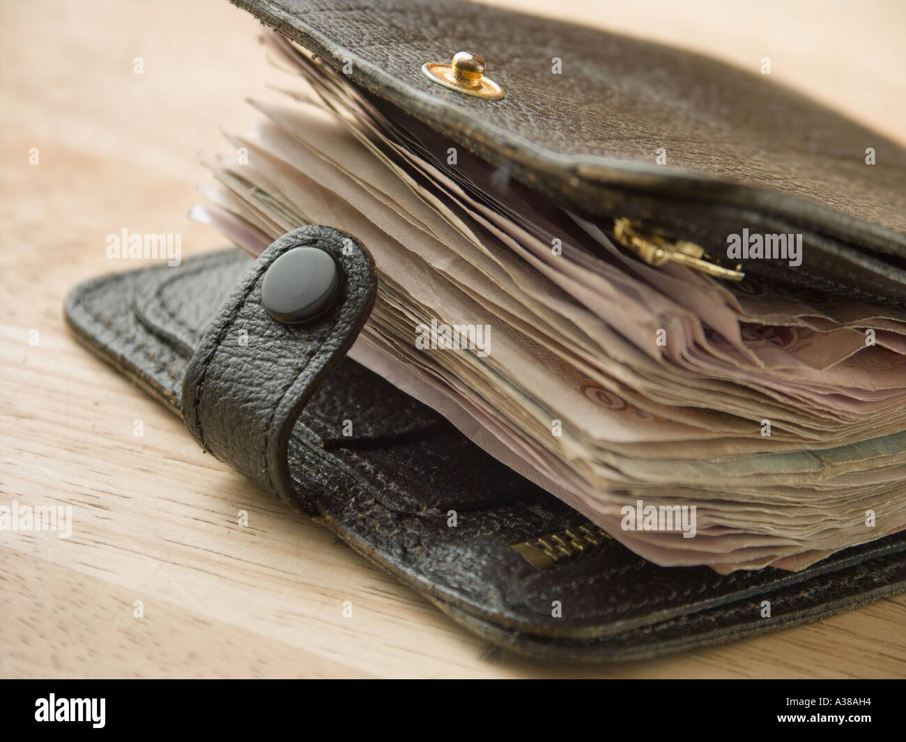 A wad of money in a black leather wallet Stock Photo - Alamy