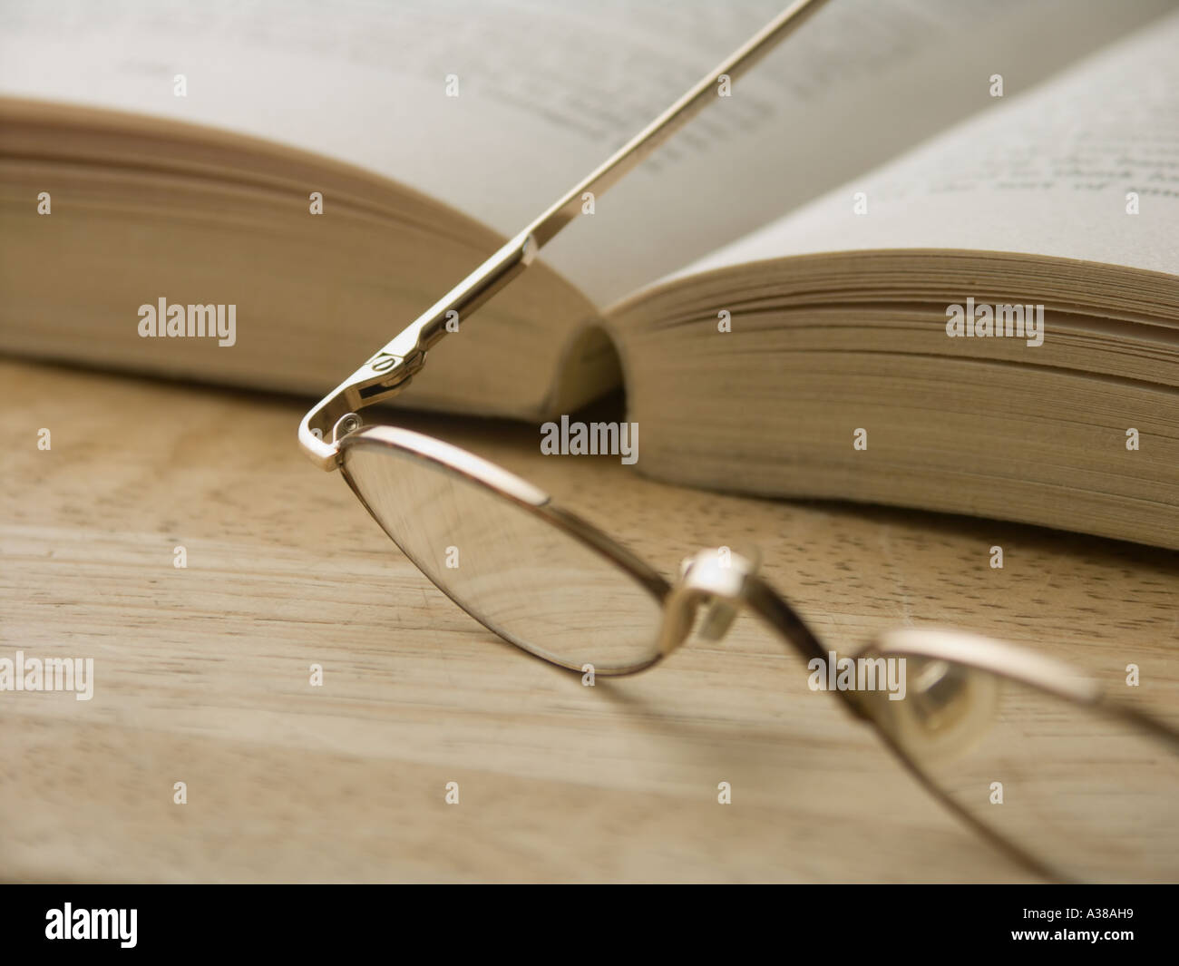 Gold rimmed reading glasses and book Stock Photo - Alamy